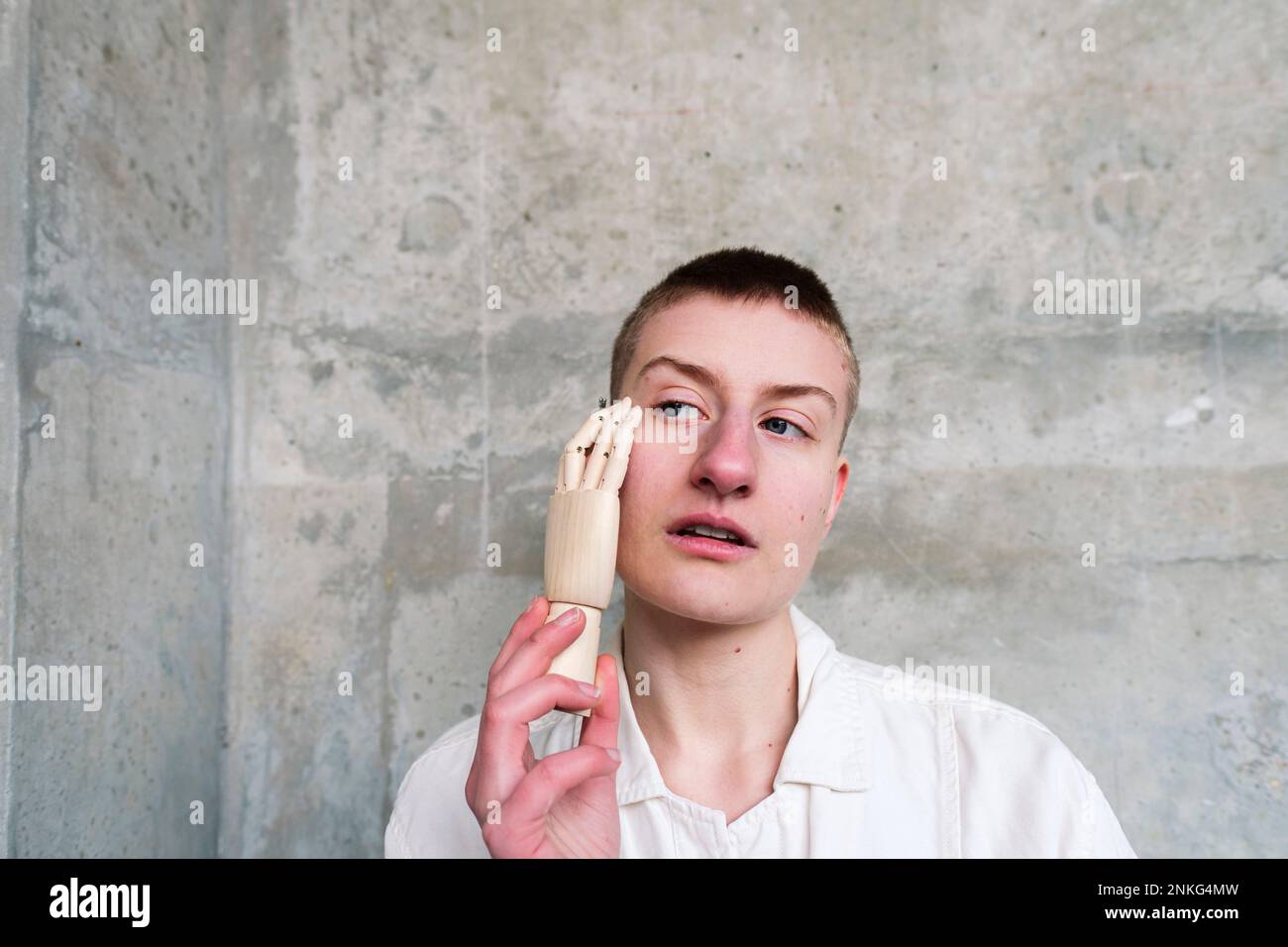 Non-binary person touching face with robotic hand Stock Photo - Alamy