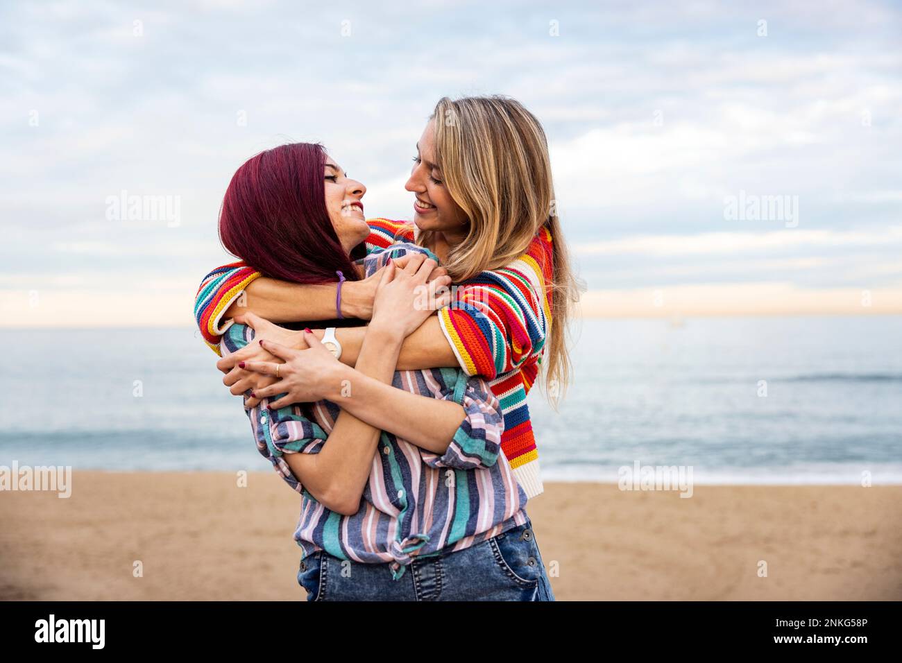 Woman hugging friend from behind at beach Stock Photo - Alamy