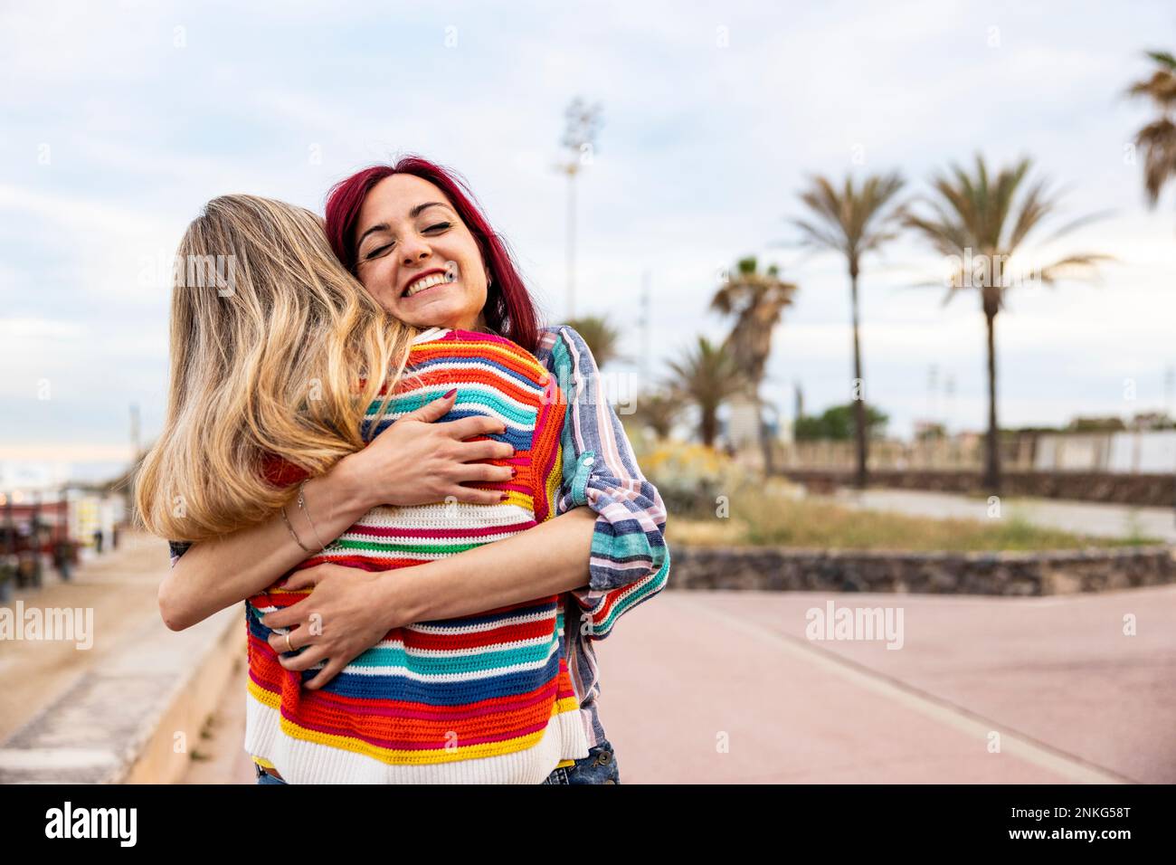 Happy friends embracing each other at promenade Stock Photo - Alamy