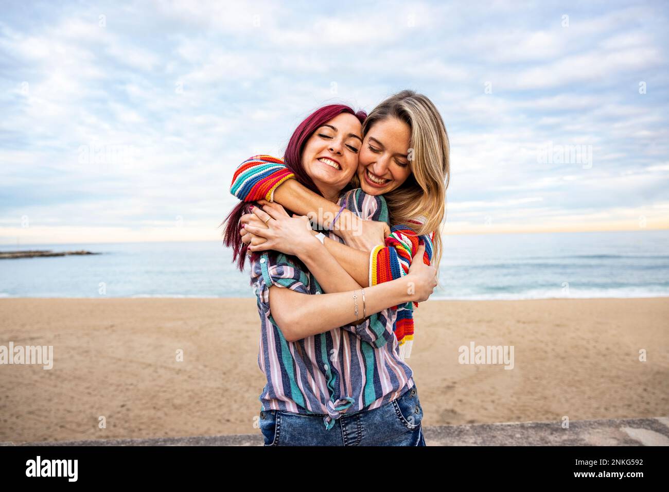 Happy woman hugging friend from behind at beach Stock Photo - Alamy
