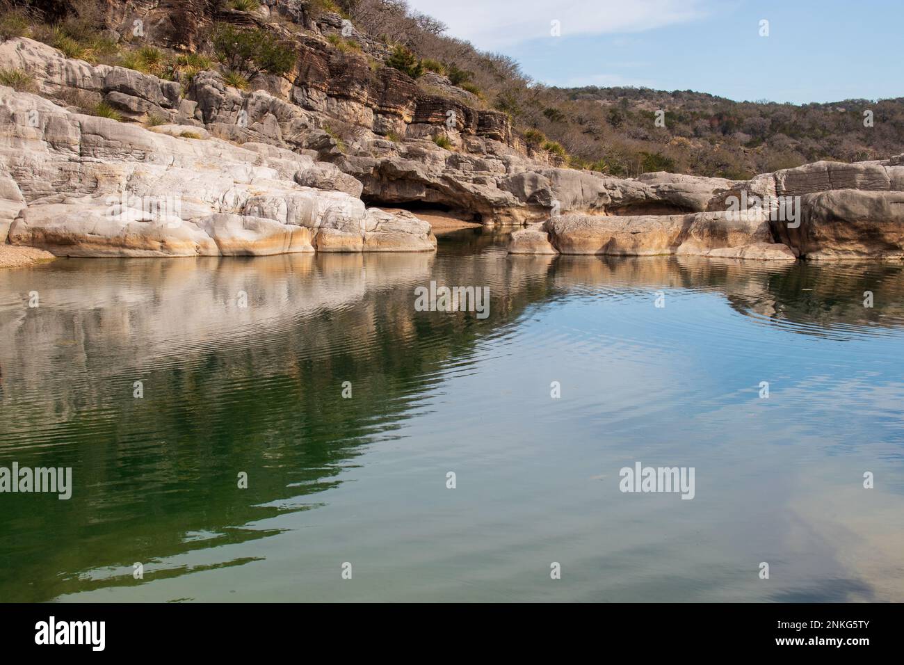 A wall of geological limestone formations creates a canyon and cliff ...