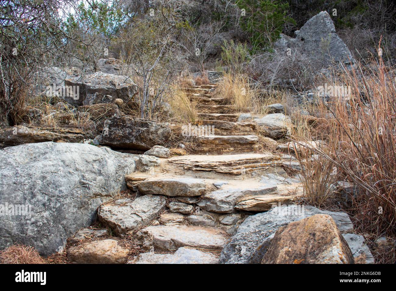 A stone staircase leads up the hill between limestone boulders and ...