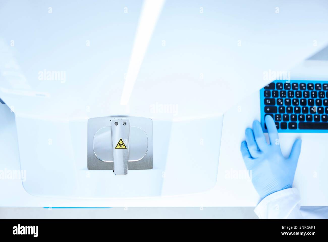 High angle view of scientist's hand and computer keyboard in a lab ...