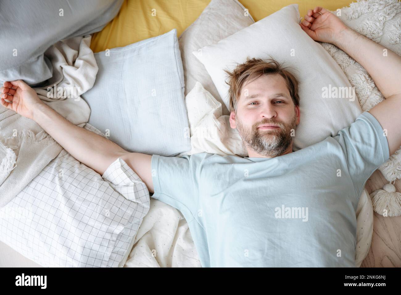 Man waking up on bed at home Stock Photo - Alamy