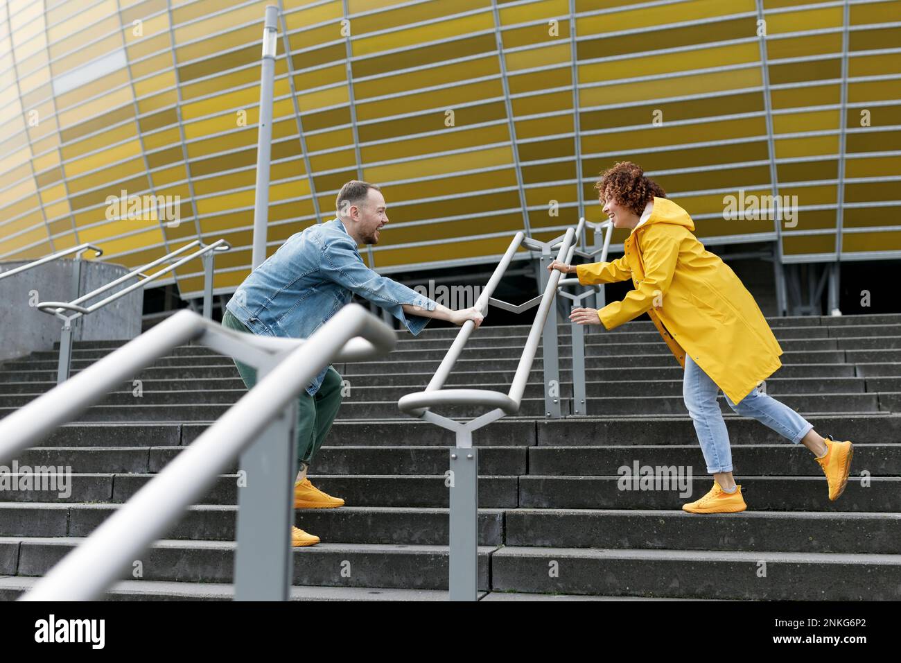 Happy couple playing on staircase outside stadium Stock Photo - Alamy
