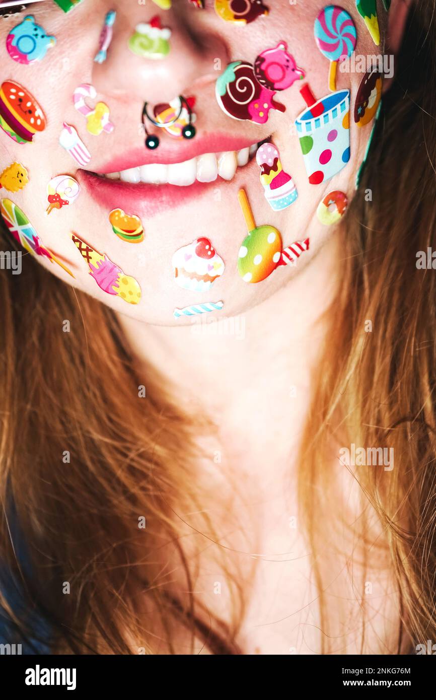 Woman with stickers on face biting lip Stock Photo - Alamy