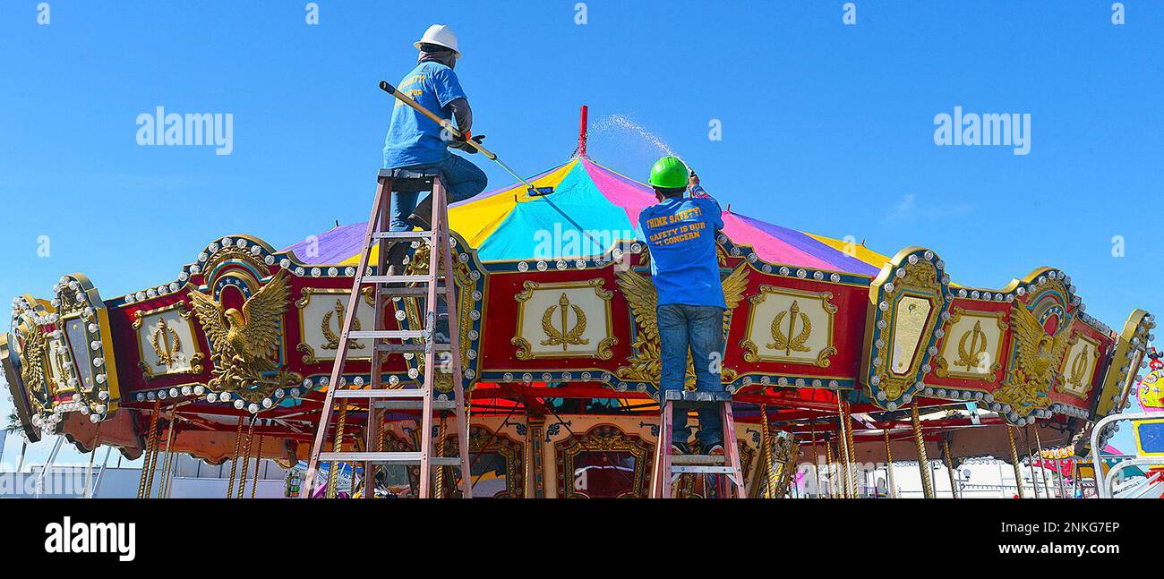 Workers with Brown's Amusements wash the "Carousel" on the carnival ...
