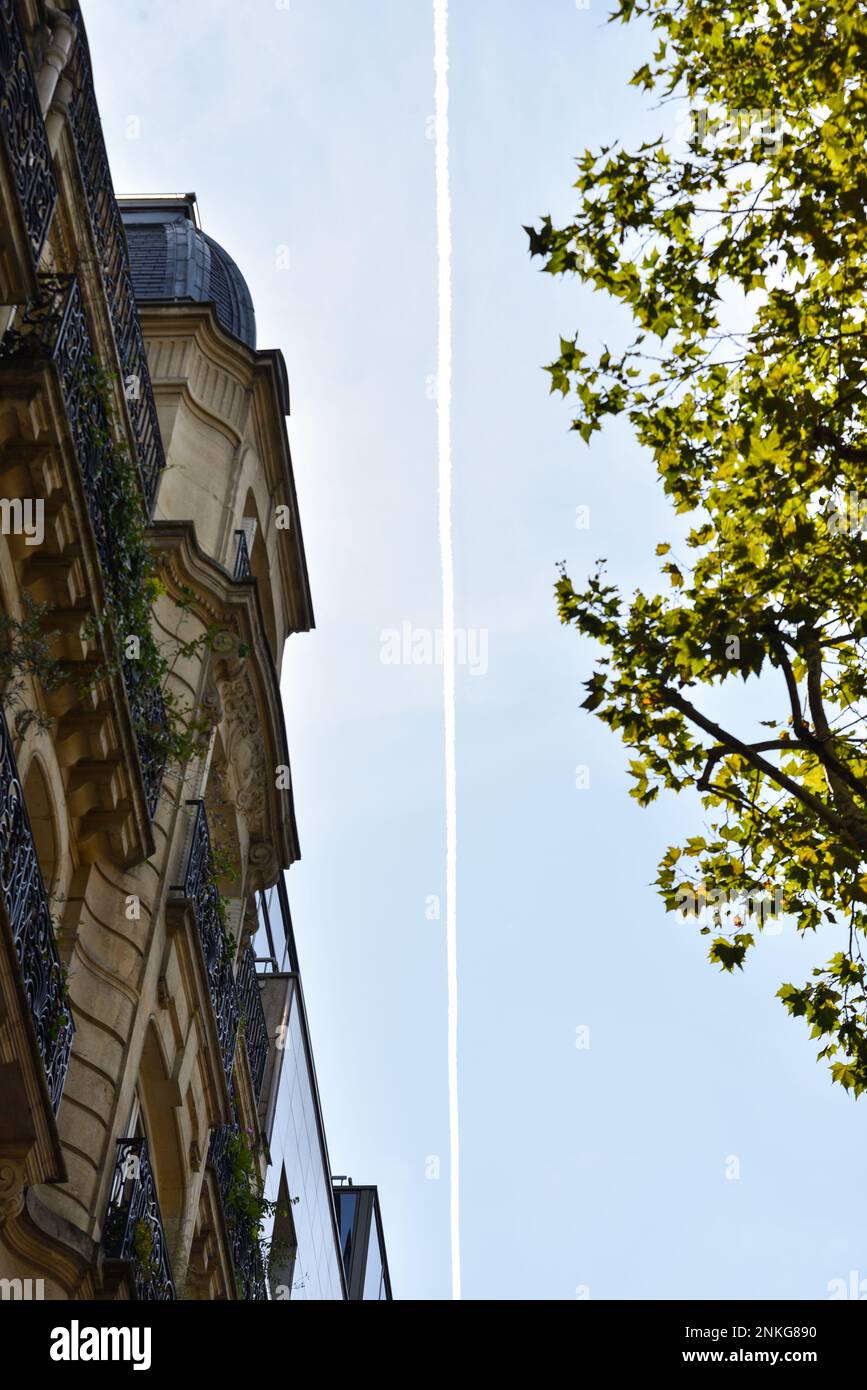 An Aircraft’s Contrail Drawing a Line in the Sky Between Buildings and ...