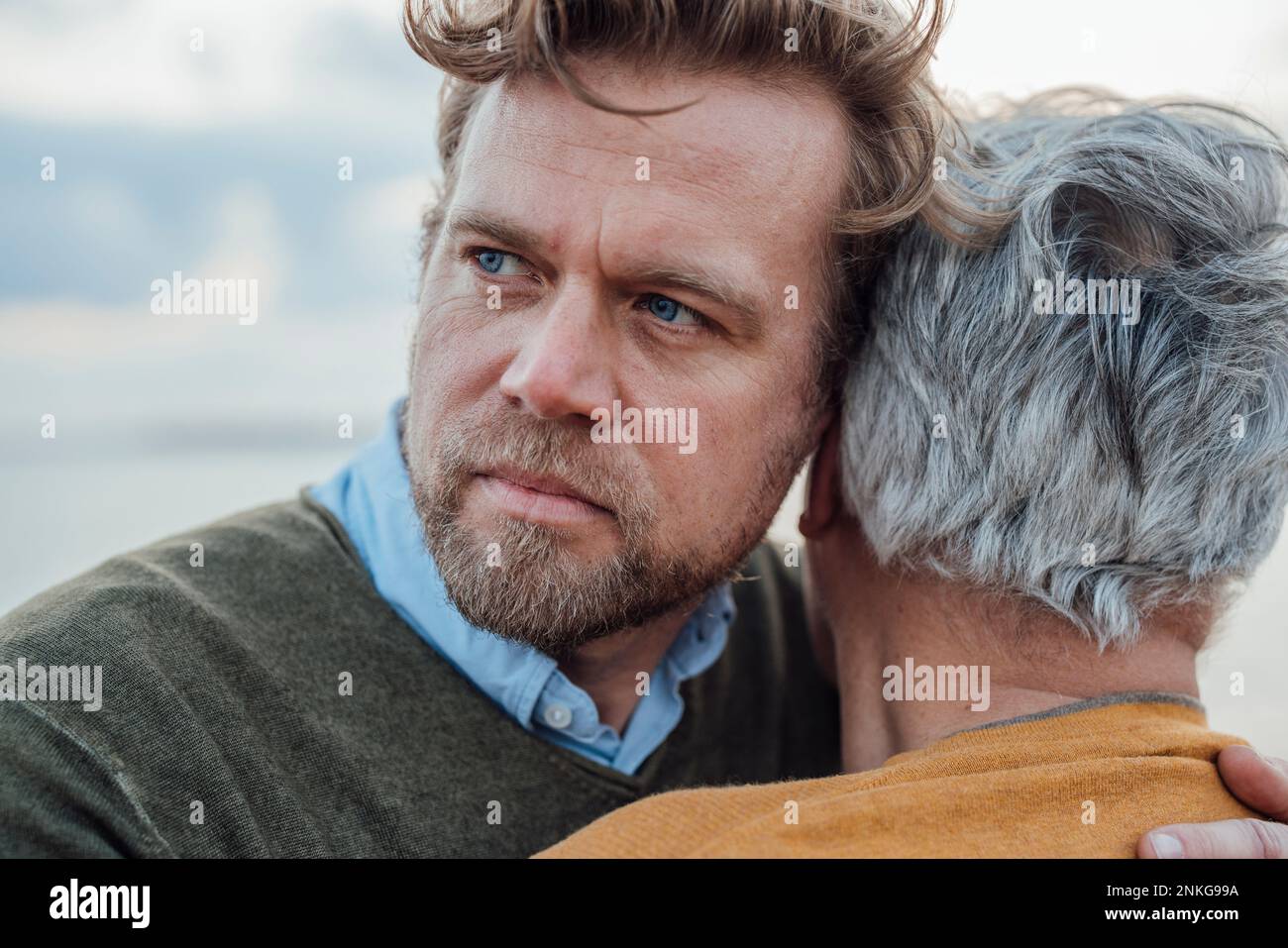 Mature man with beard hugging father Stock Photo - Alamy