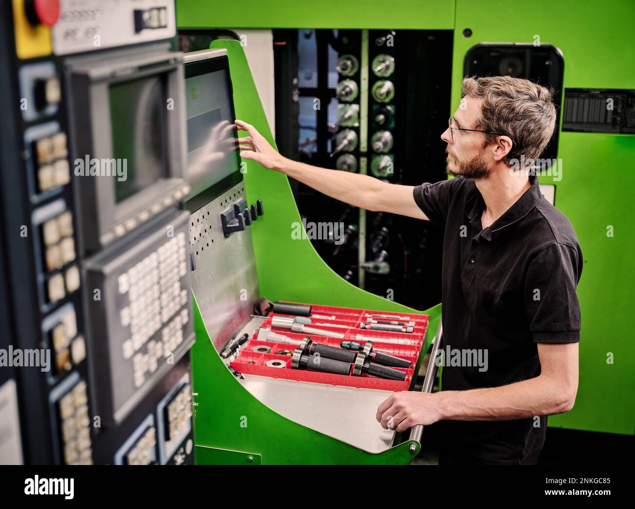 Technician operating machine in modern factory Stock Photo - Alamy