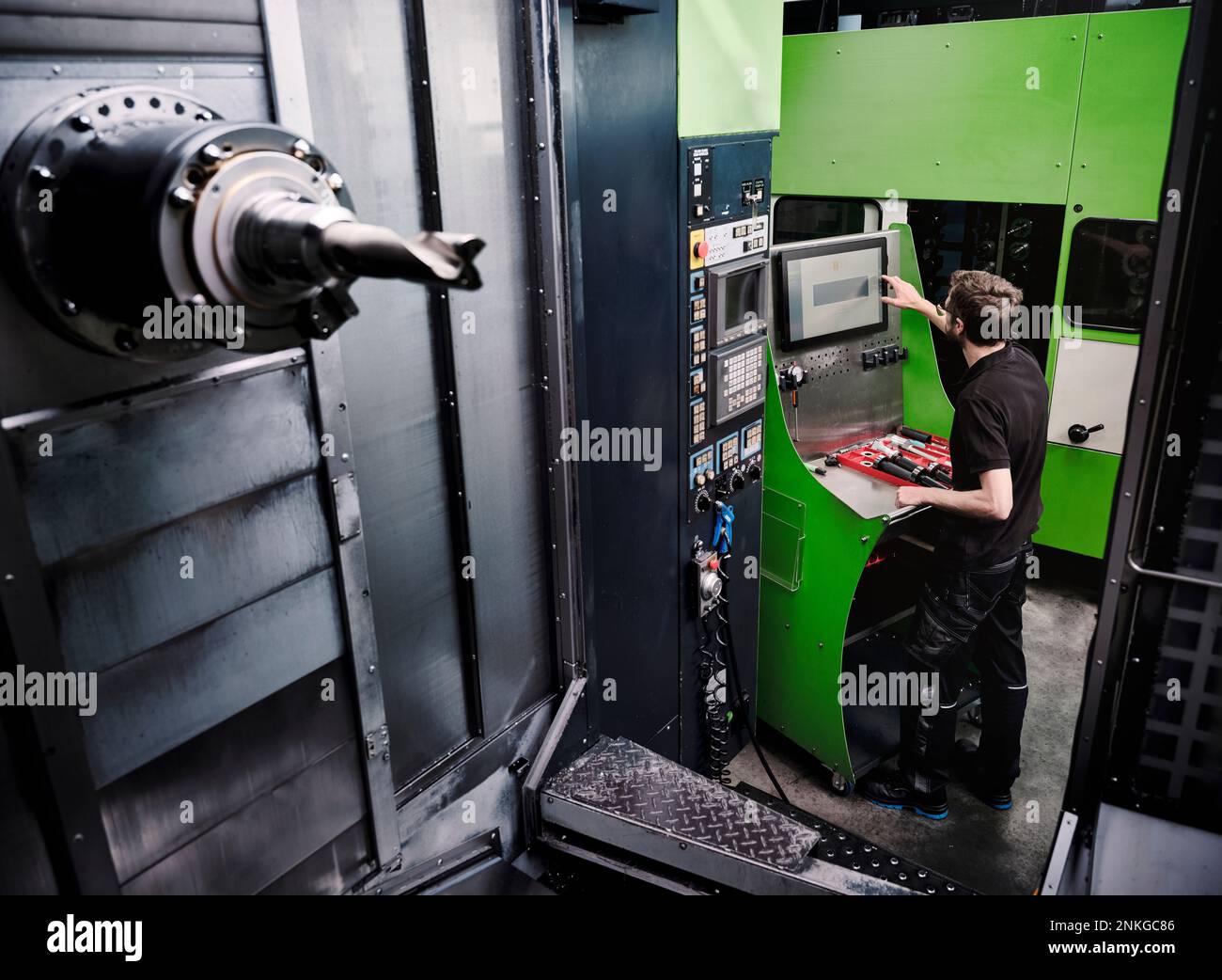 Technician operating machine in modern factory Stock Photo - Alamy