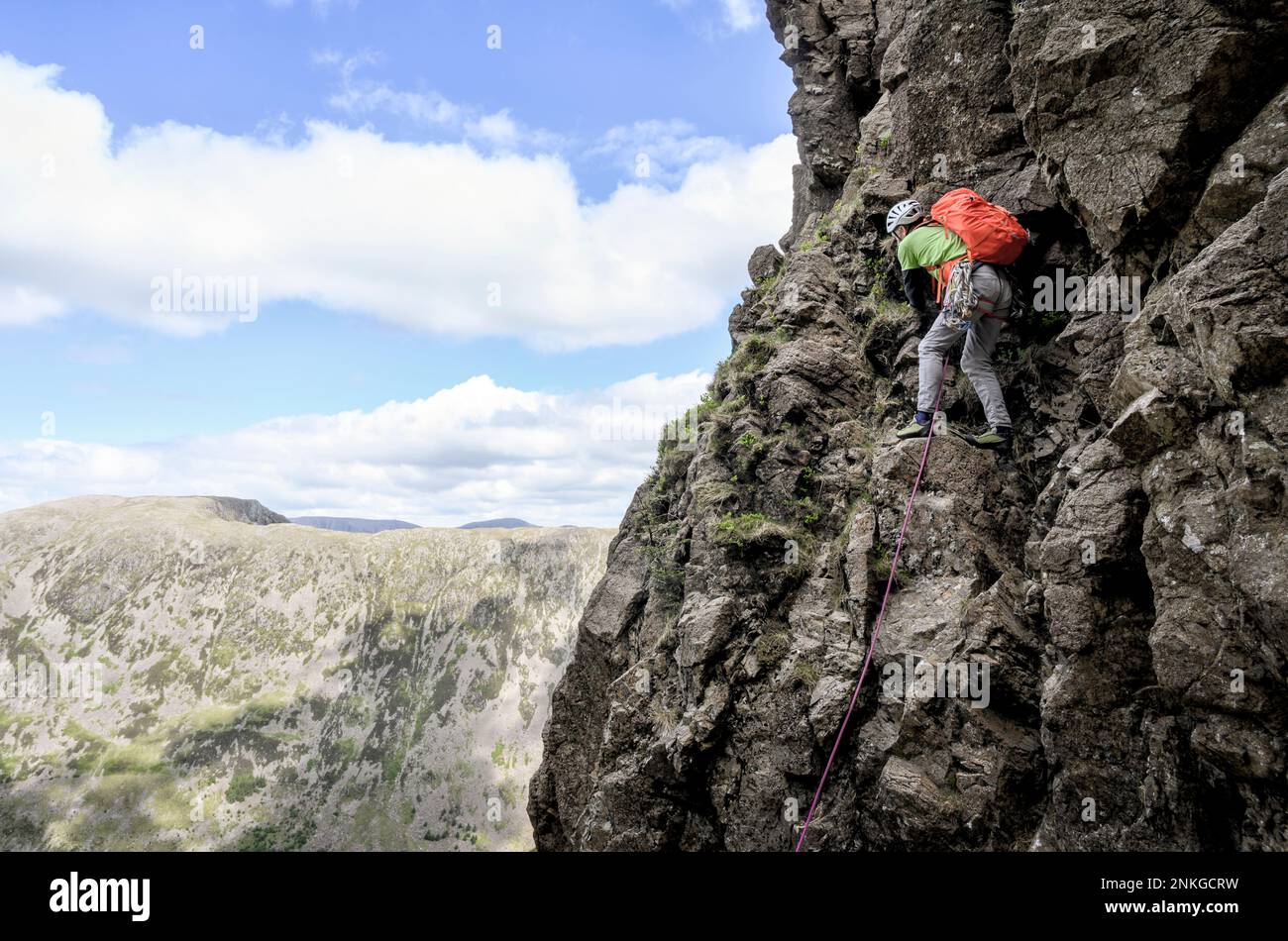 Man wearing backpack climbing on mountain, Lake District, England Stock ...
