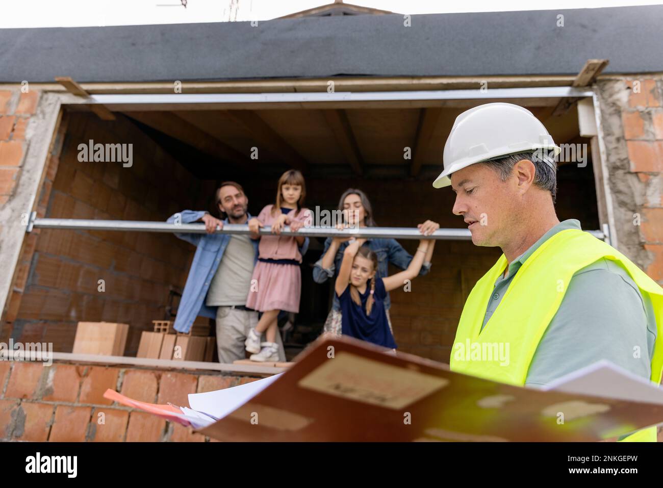 Contractor with family seen through window at construction site Stock ...