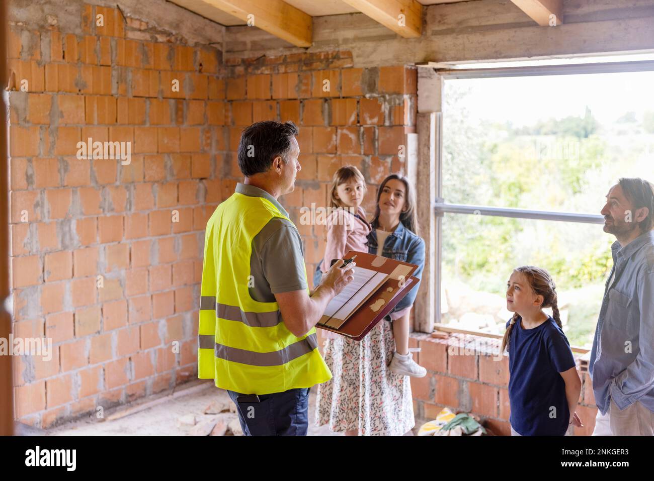 Architect having discussion with family at construction site Stock ...