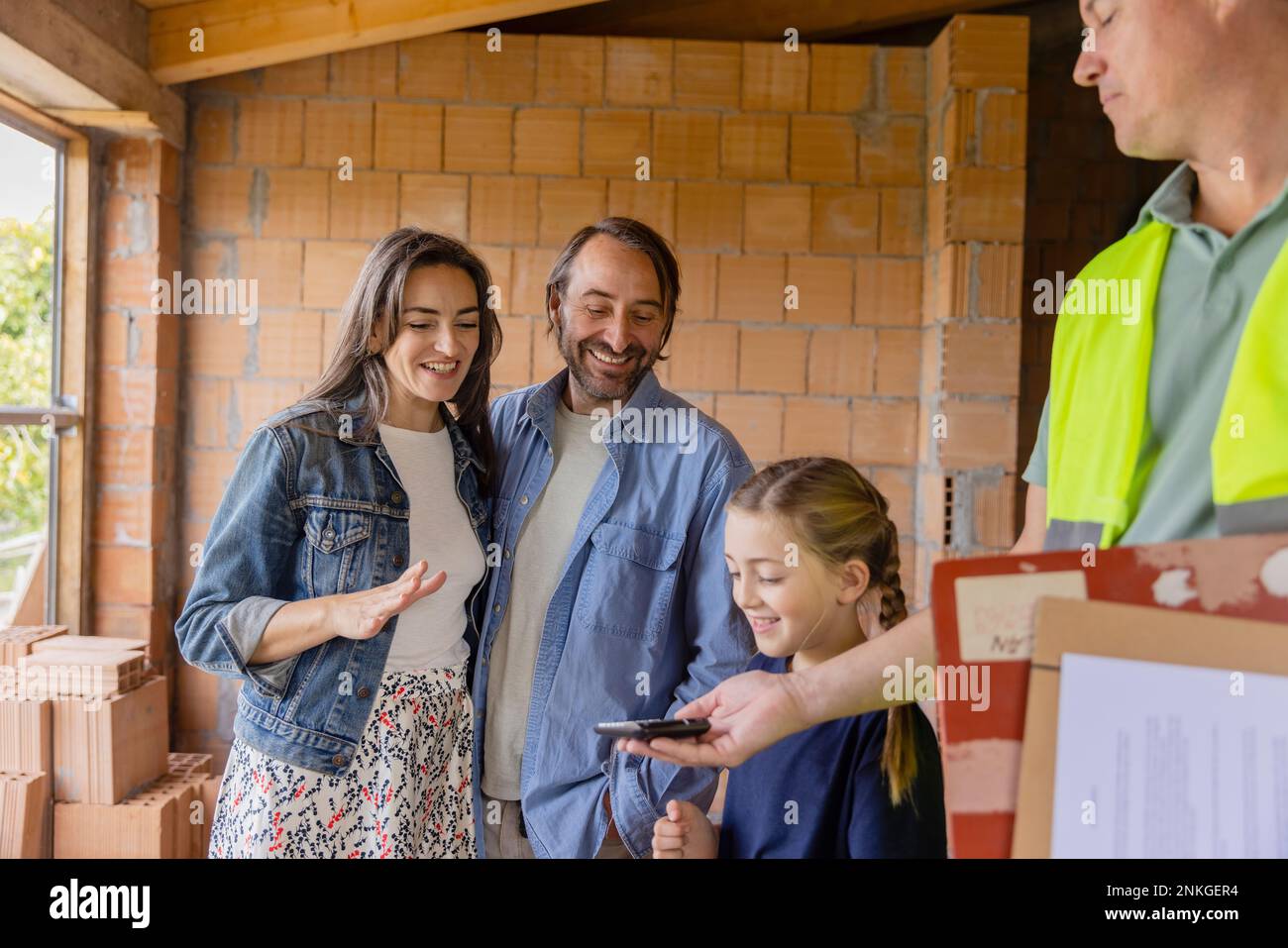 Contractor having discussion with family over smart phone Stock Photo ...