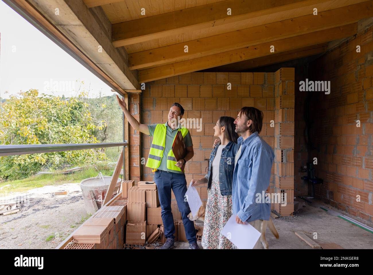 Happy contractor having discussion with mature couple at construction ...