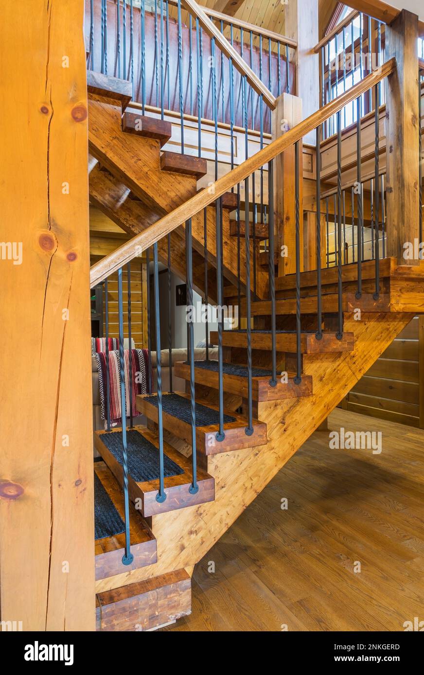 Wooden staircase and banister with black wrought iron spindles and ...