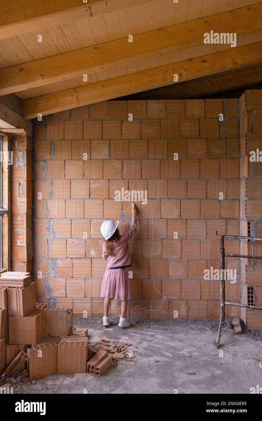 Girl with chalk drawing on brick wall at construction site Stock Photo ...