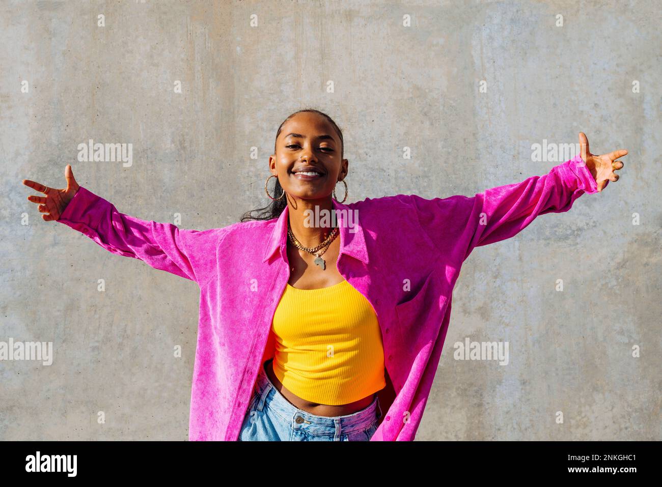 Happy dancer with arms outstretched dancing in front of wall Stock ...