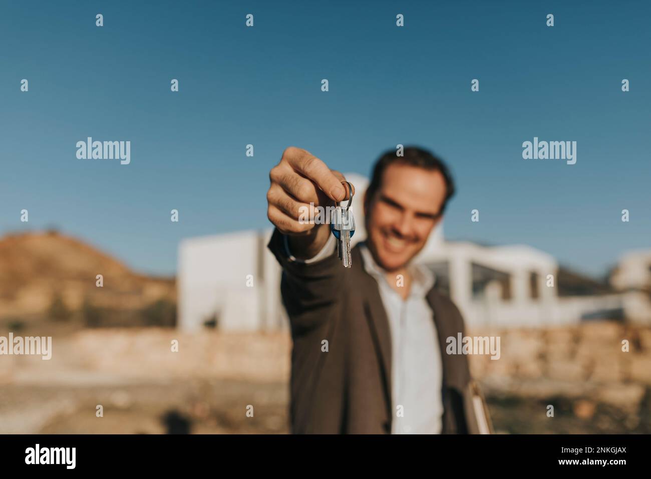 Hands of man showing new house key Stock Photo - Alamy
