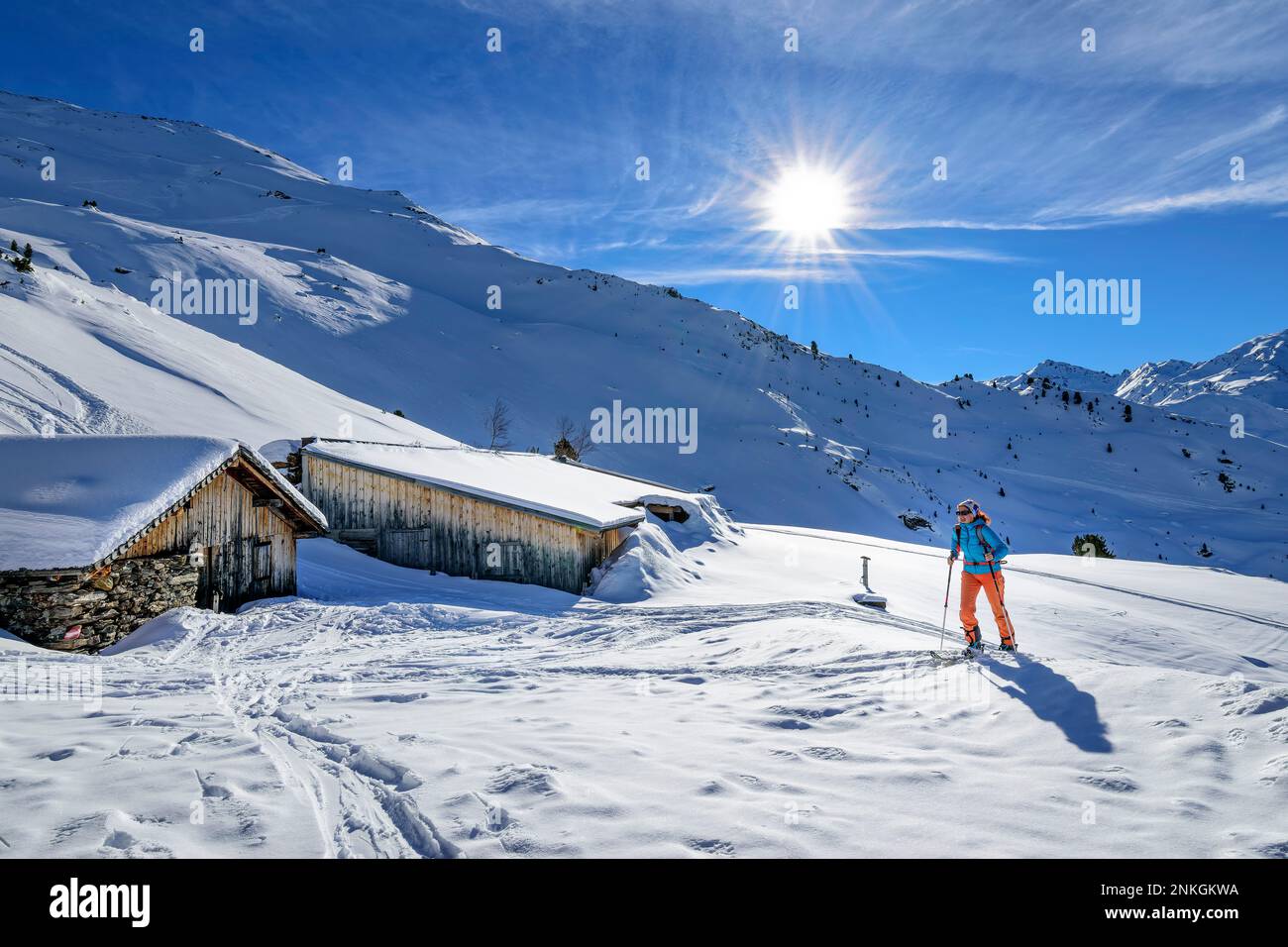 Sun shining female skier passing secluded huts tux alps hi-res stock ...
