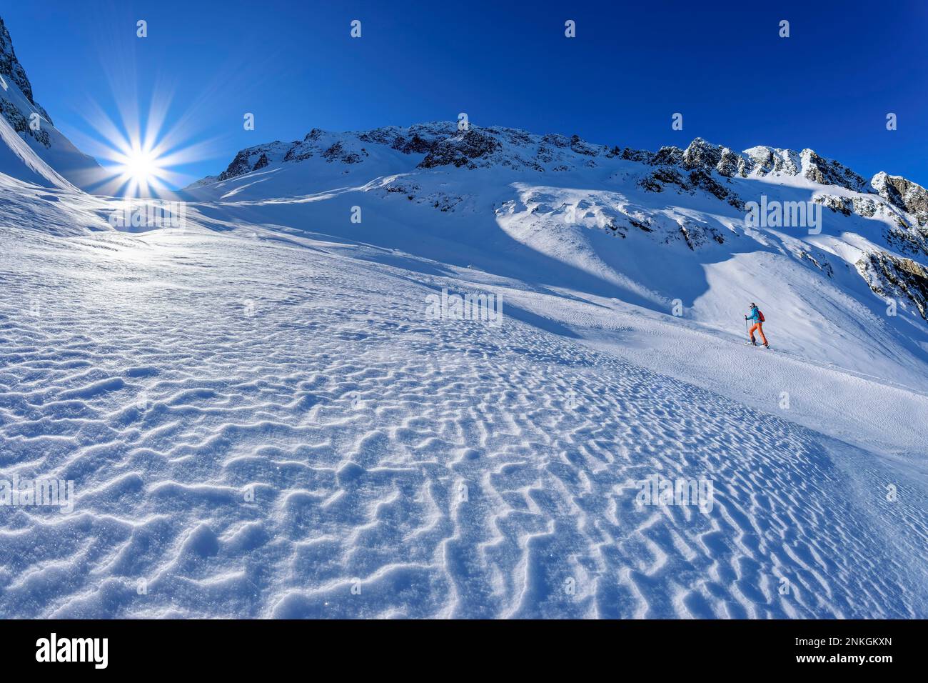 Female skier ascending slope zillertal alps sun shining background hi ...