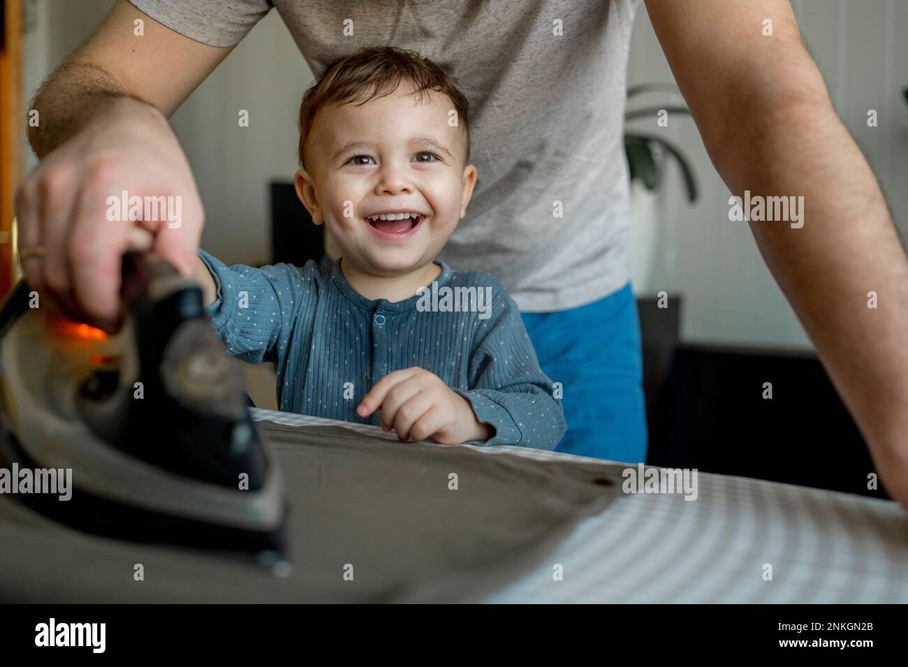 Happy cute son helping father to iron clothes at home Stock Photo - Alamy