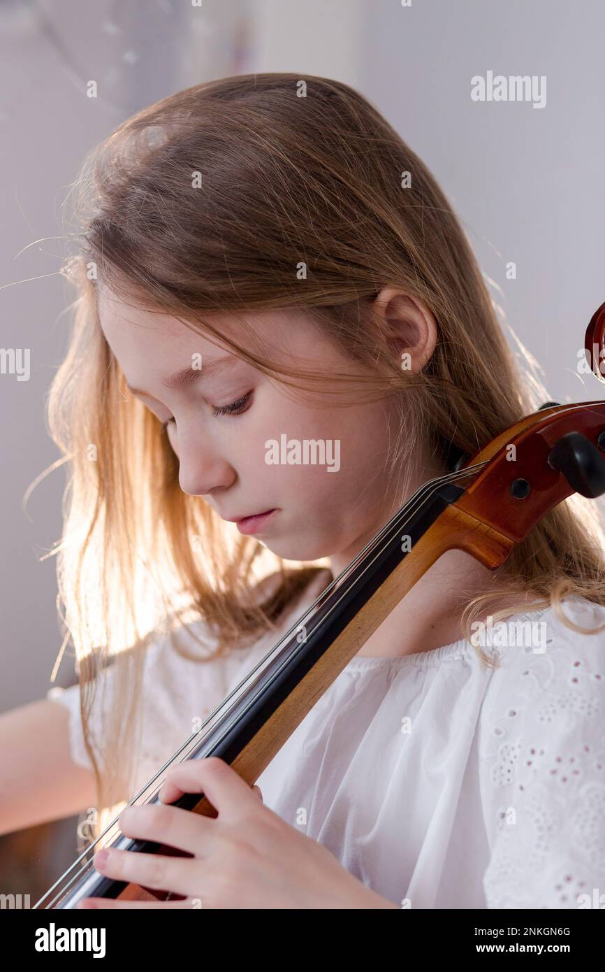 Girl practicing cello at home Stock Photo - Alamy