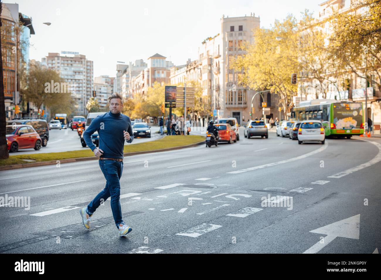 Man running and crossing road in city Stock Photo - Alamy