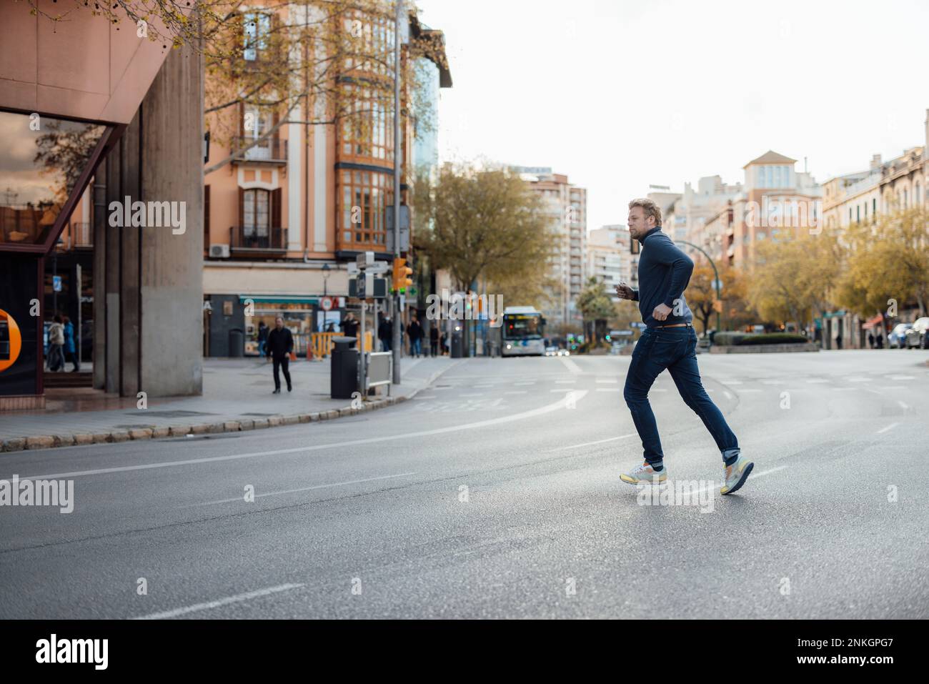Man running on road in city Stock Photo - Alamy