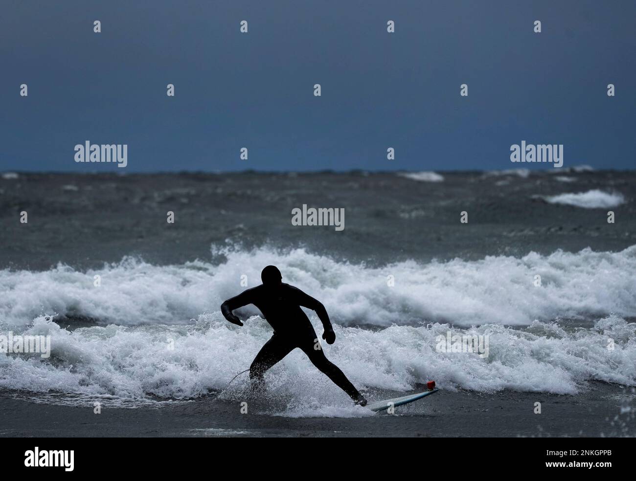 Robert Homola surfs on a cool and windy spring day on Lake Ontario in ...