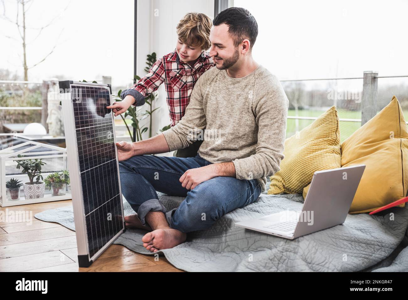 Son touching solar panel by father at home Stock Photo - Alamy