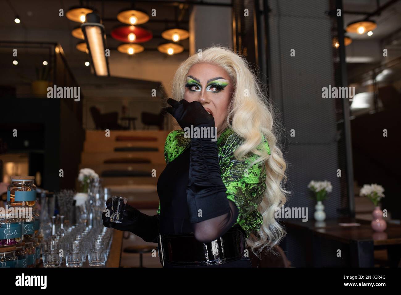 Blond drag queen having vodka shot in bar Stock Photo - Alamy
