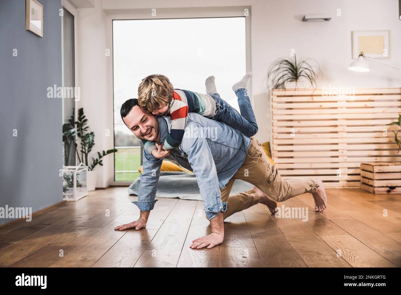 Boy balancing on back of father doing push-ups at home Stock Photo - Alamy