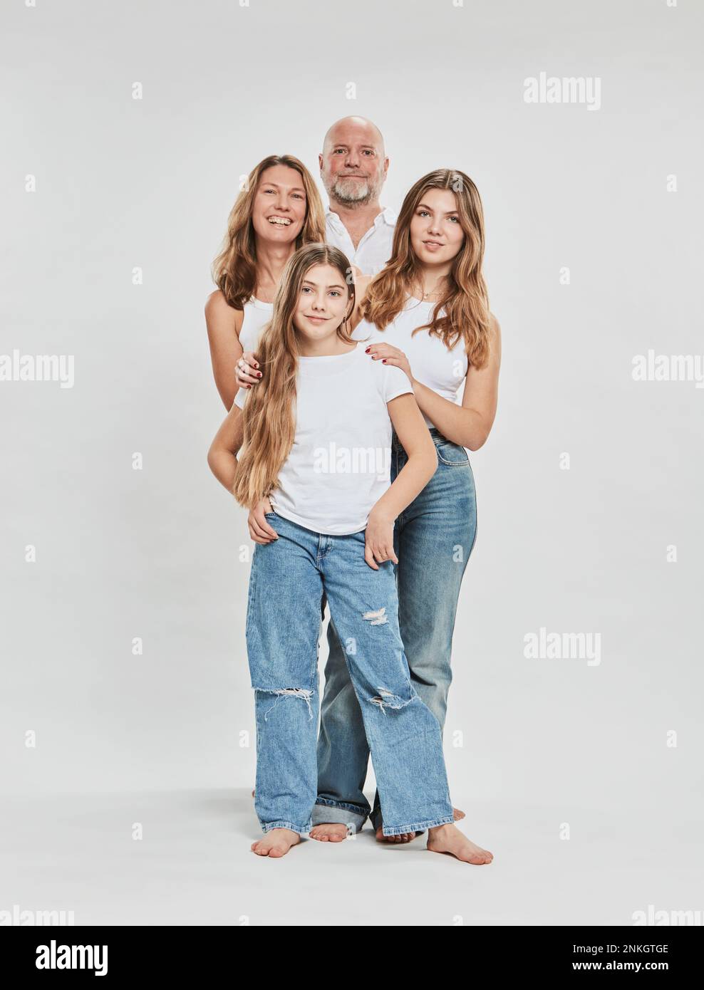 Happy family standing together against white background Stock Photo - Alamy