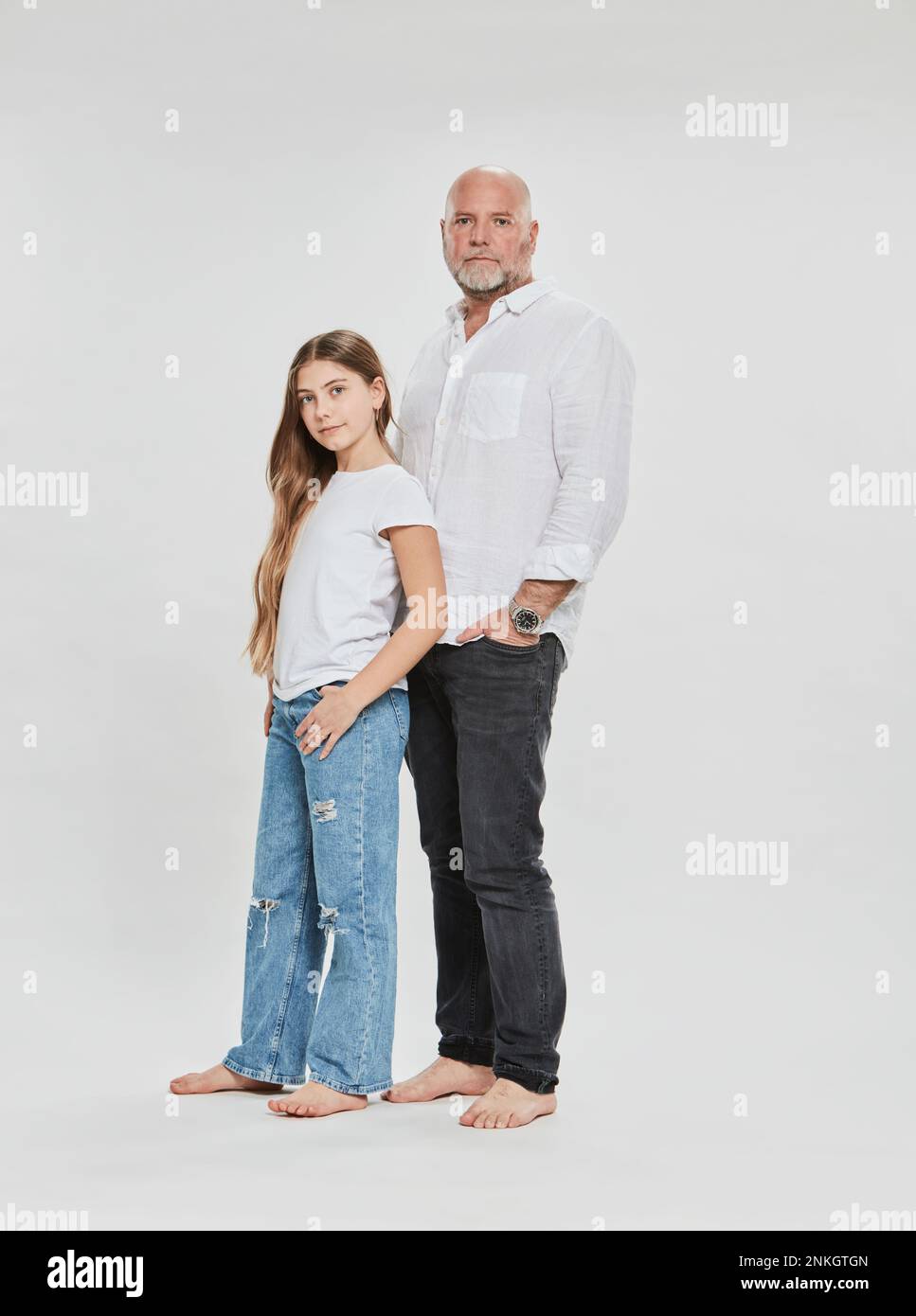 Father and daughter standing together against white background Stock ...