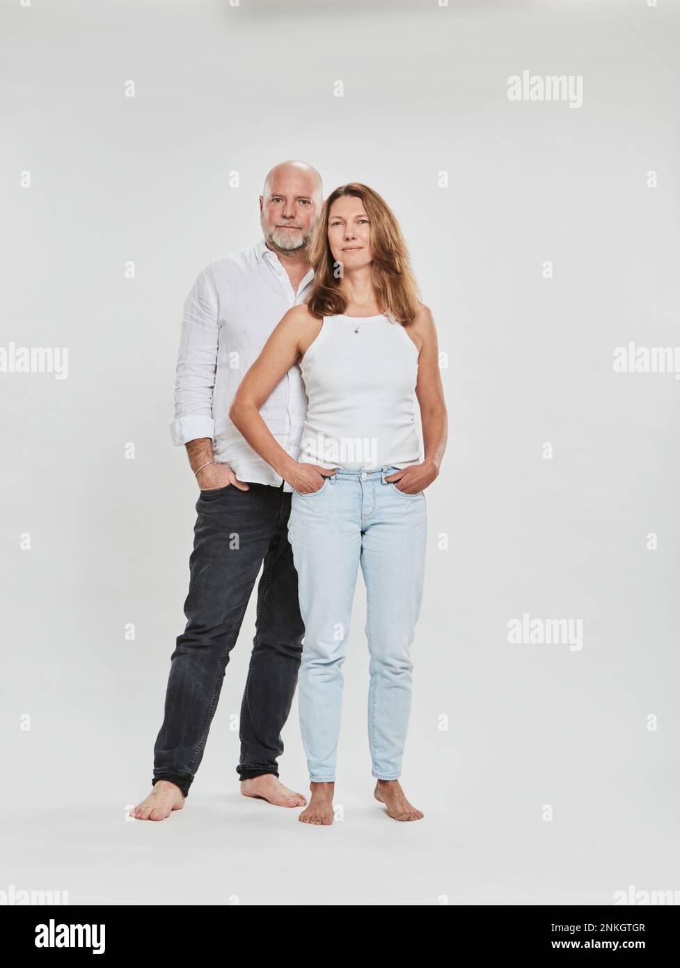 Couple standing together against white background Stock Photo - Alamy