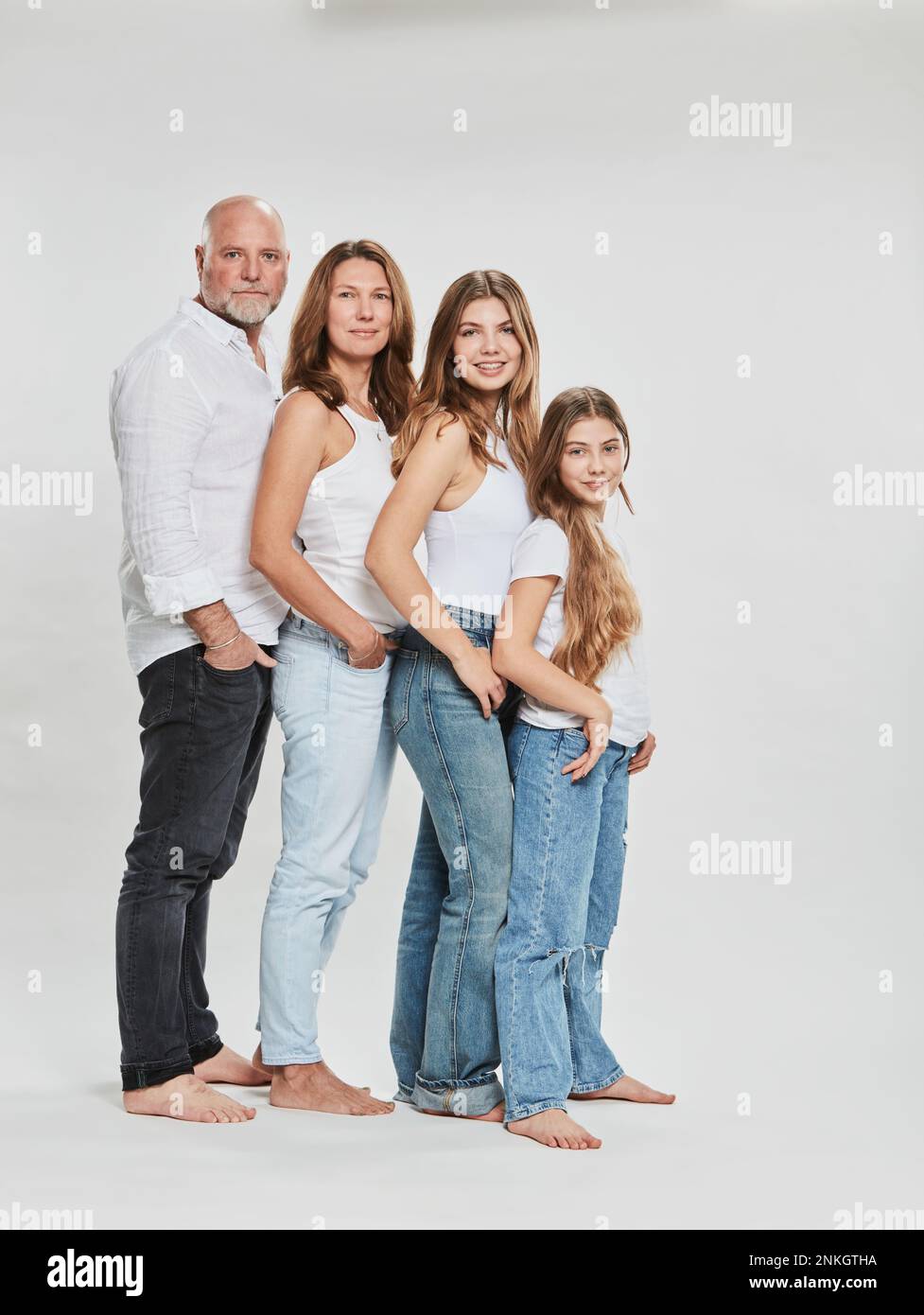 Family standing in line against white background Stock Photo - Alamy