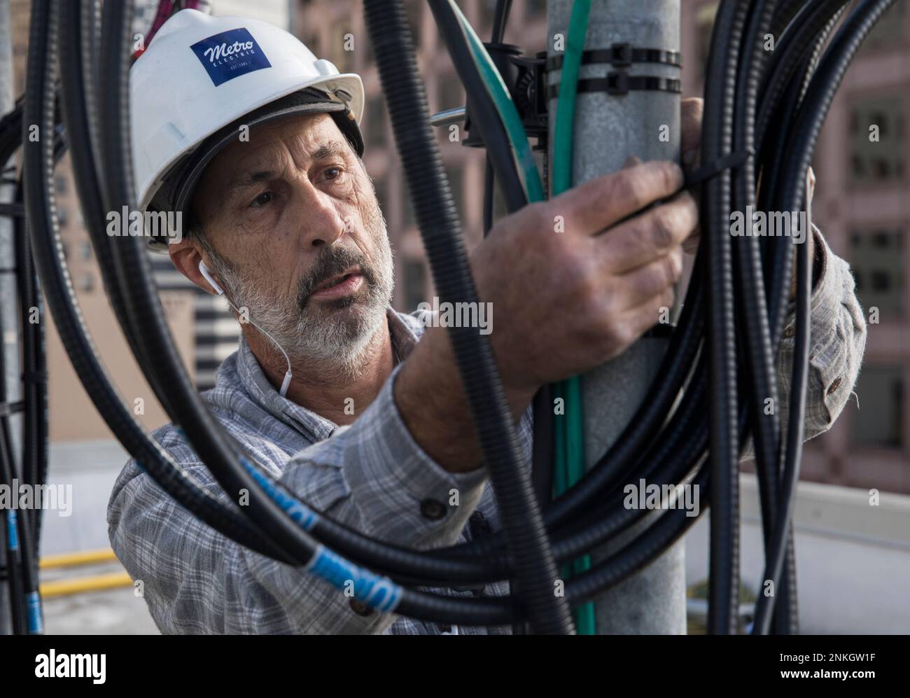 Technician Tim Felker secures wires while laying the infrastructure for ...