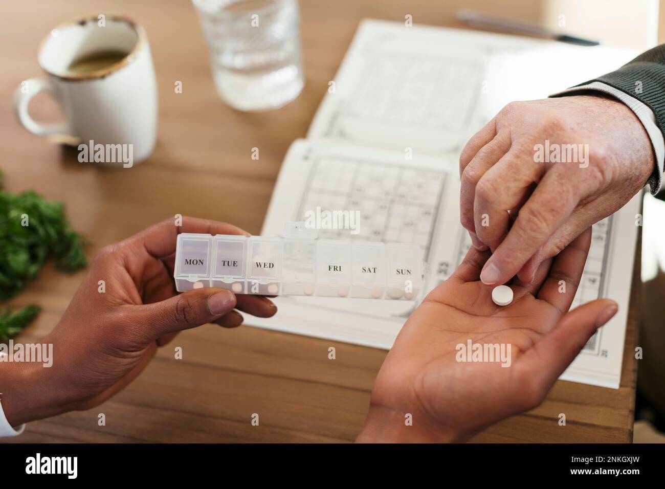 Hand of man taking pill from caretaker Stock Photo - Alamy