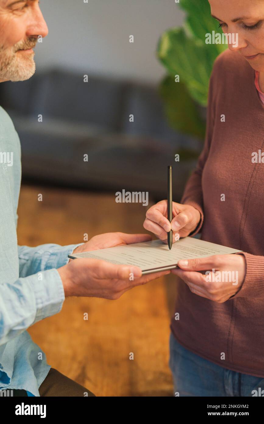 Mature salesman with customer signing agreement Stock Photo - Alamy