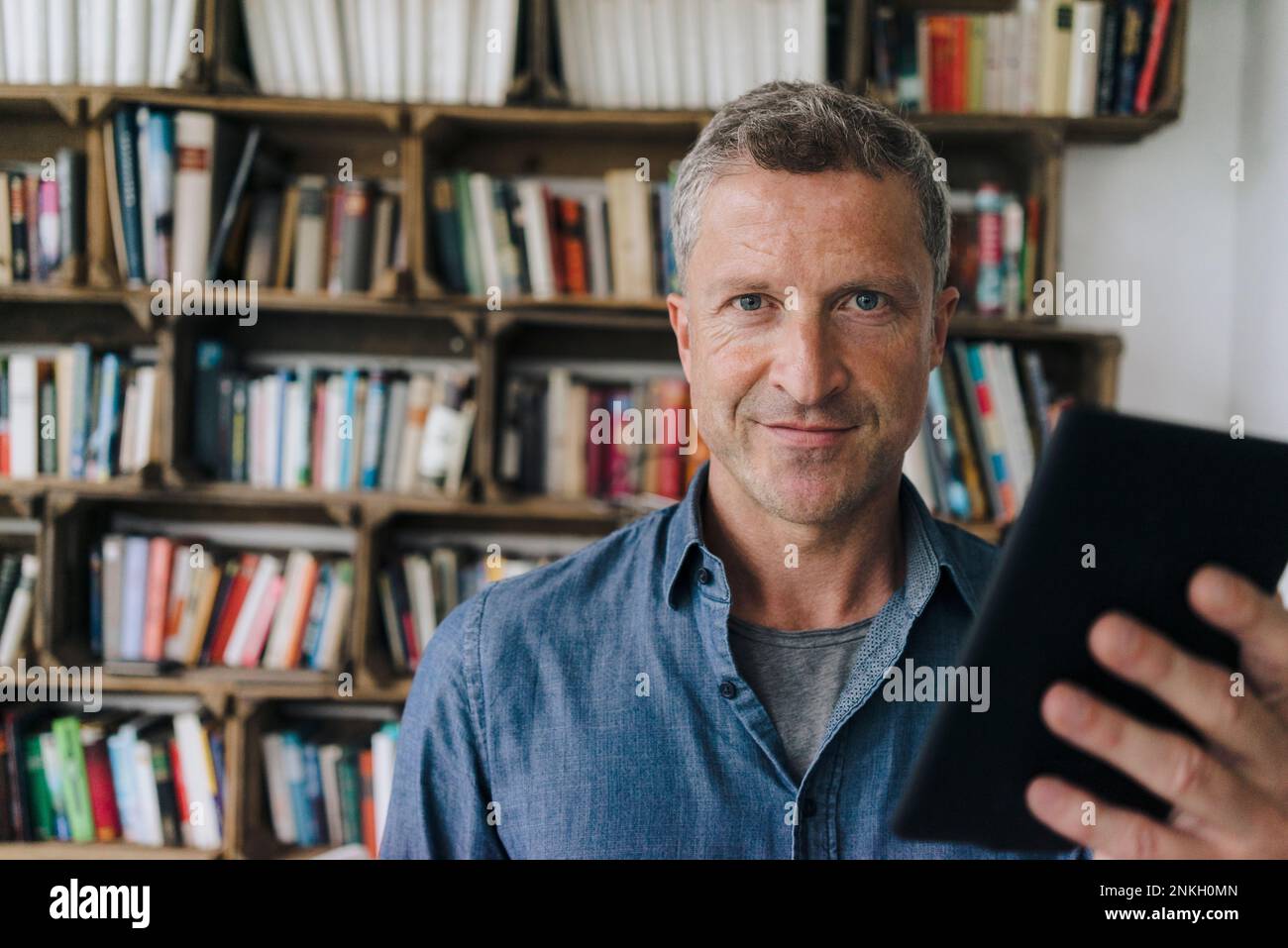 Man standing in front bookshelf hi-res stock photography and images - Alamy