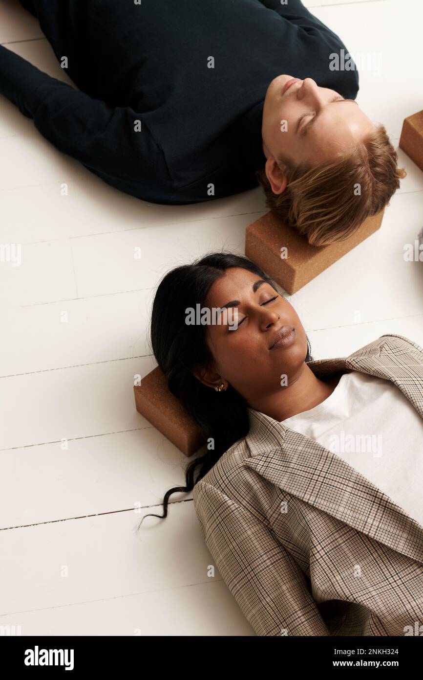 Business colleagues with eyes closed lying on yoga blocks Stock Photo ...