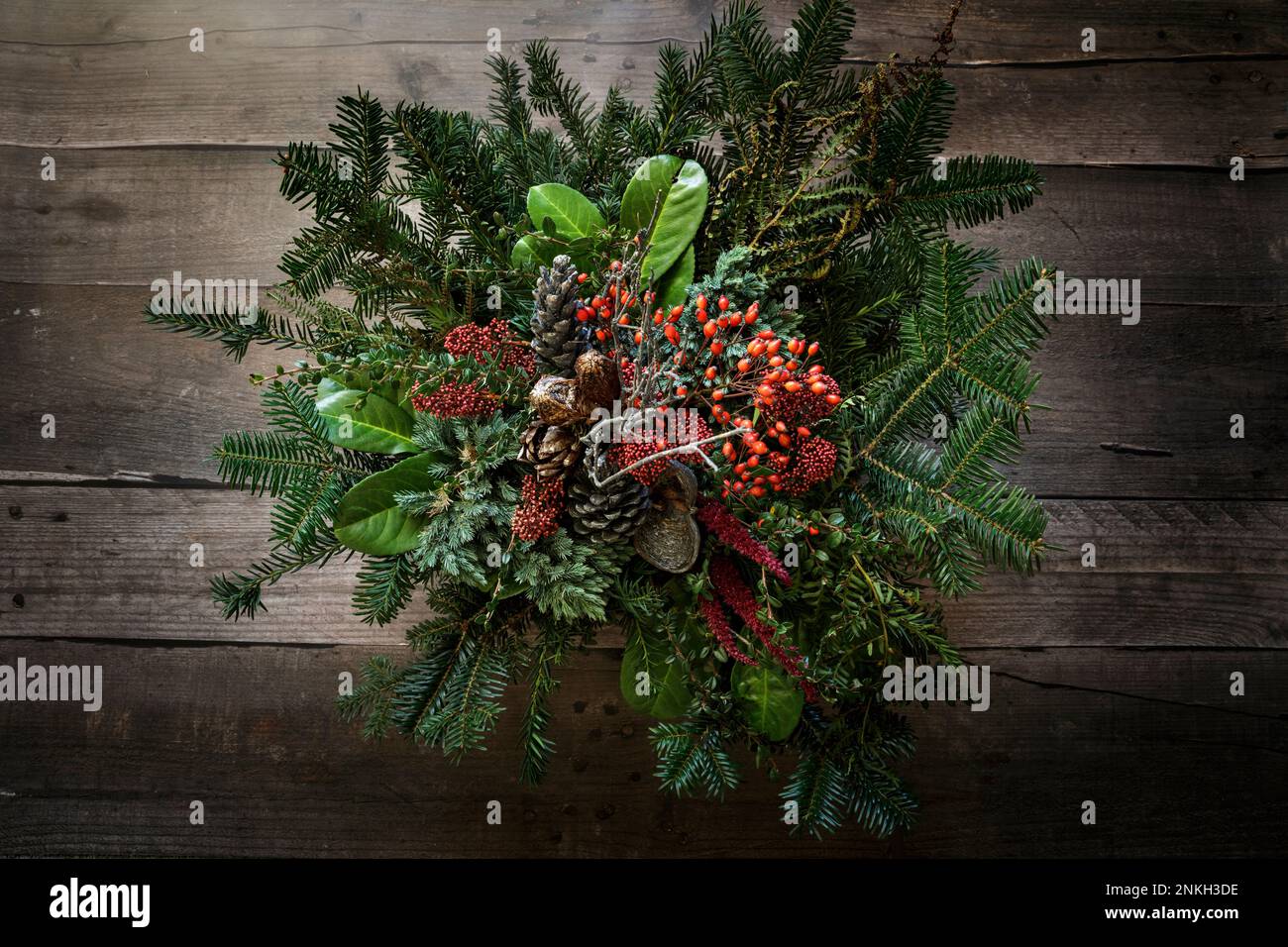 Autumnal arrangement of twigs, laurel, amaranthus, skimmia, rose hips ...
