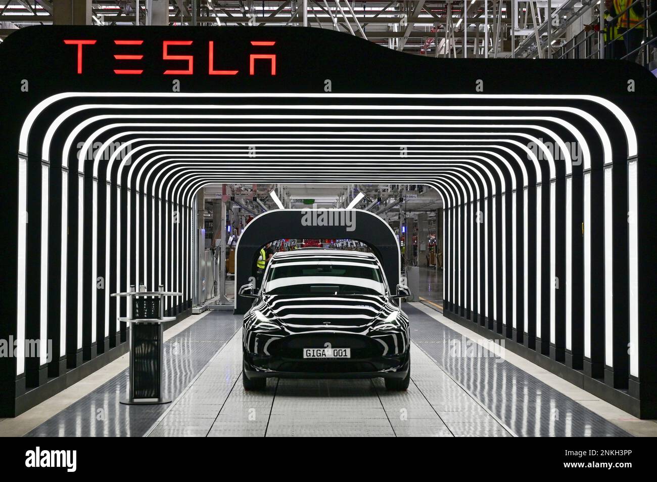 Model Y electric vehicles stand on a conveyor belt at the opening of ...