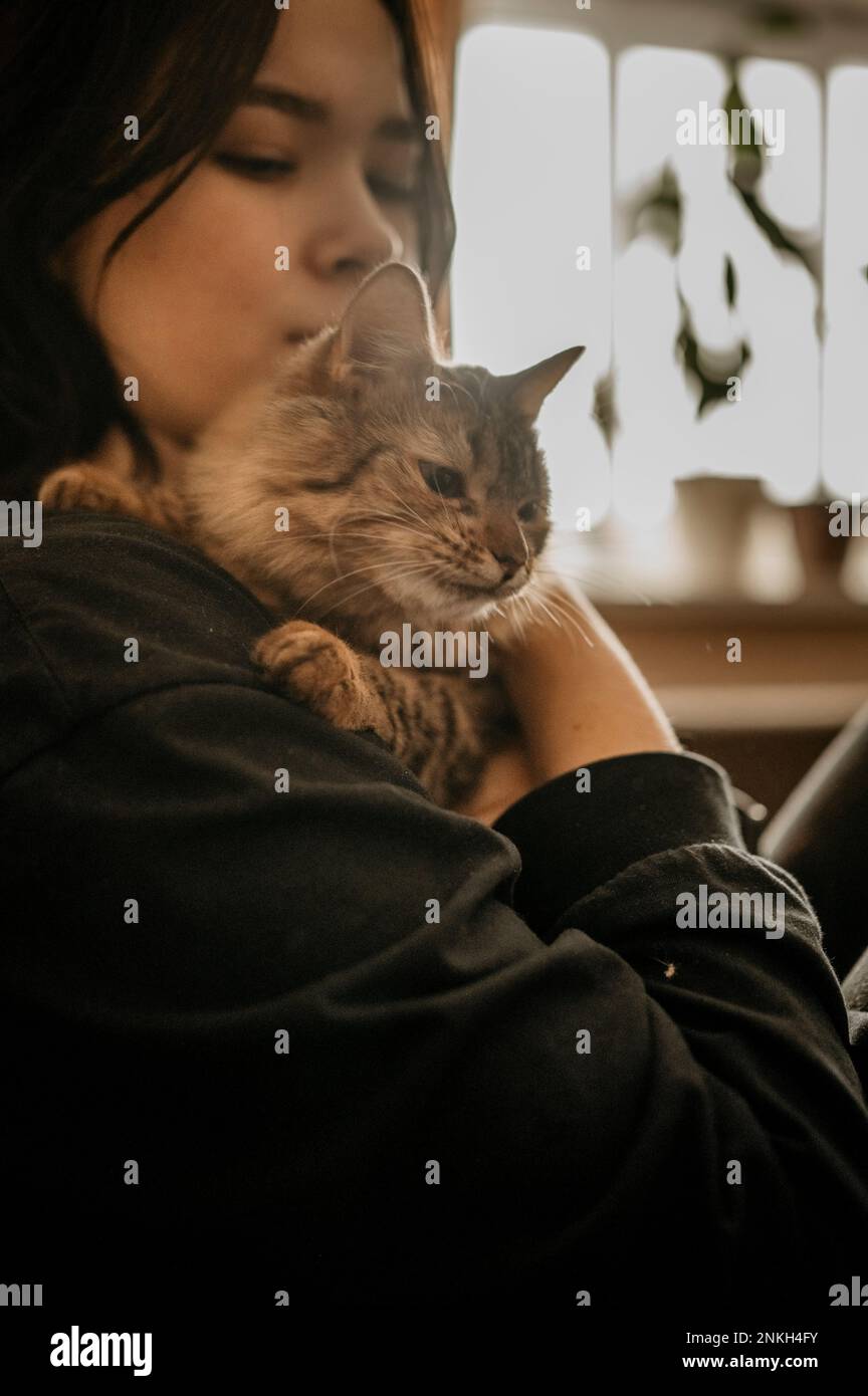 Teenage girl holding cat in arms Stock Photo - Alamy