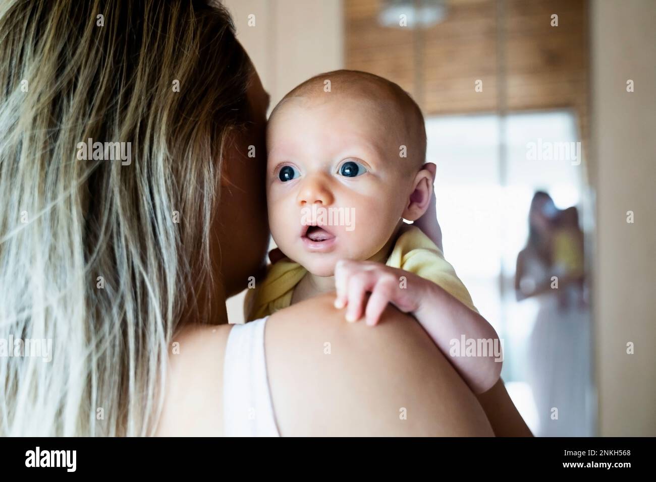 Mother carrying cute baby boy at home Stock Photo - Alamy