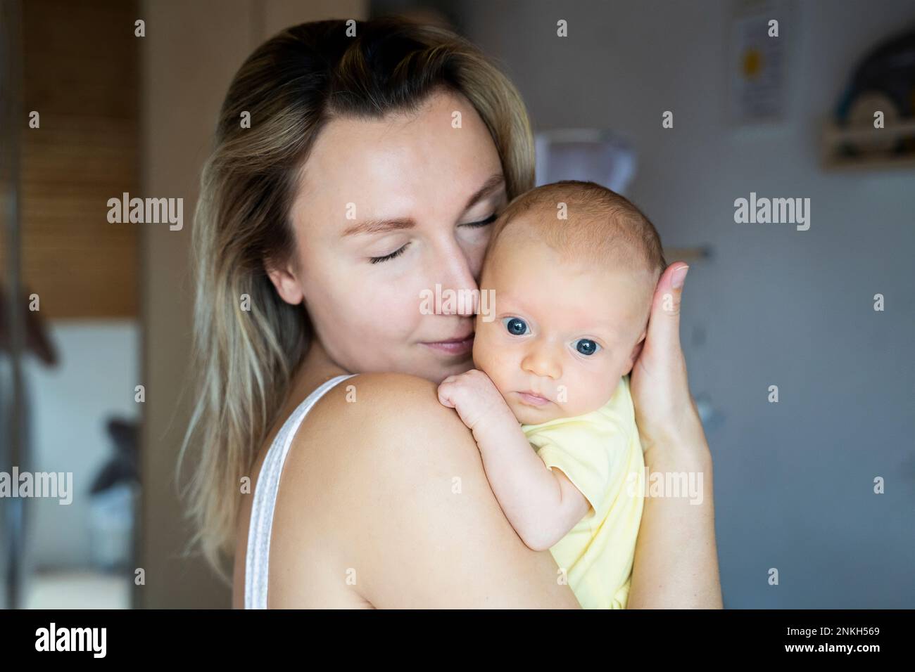 Mother with eyes closed carrying baby boy Stock Photo - Alamy