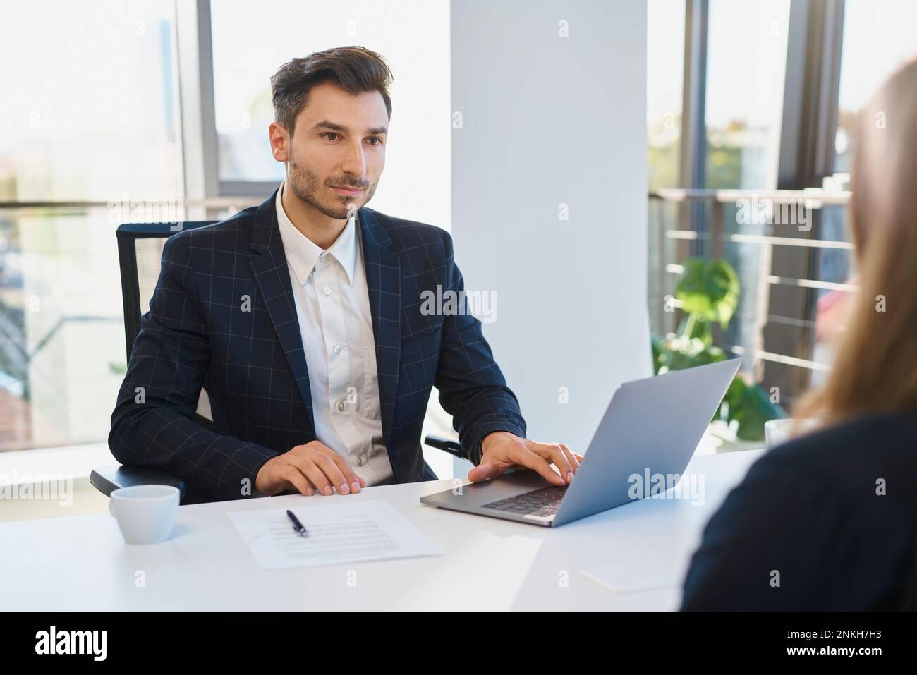 Recruiter with laptop looking at candidate in interview Stock Photo - Alamy