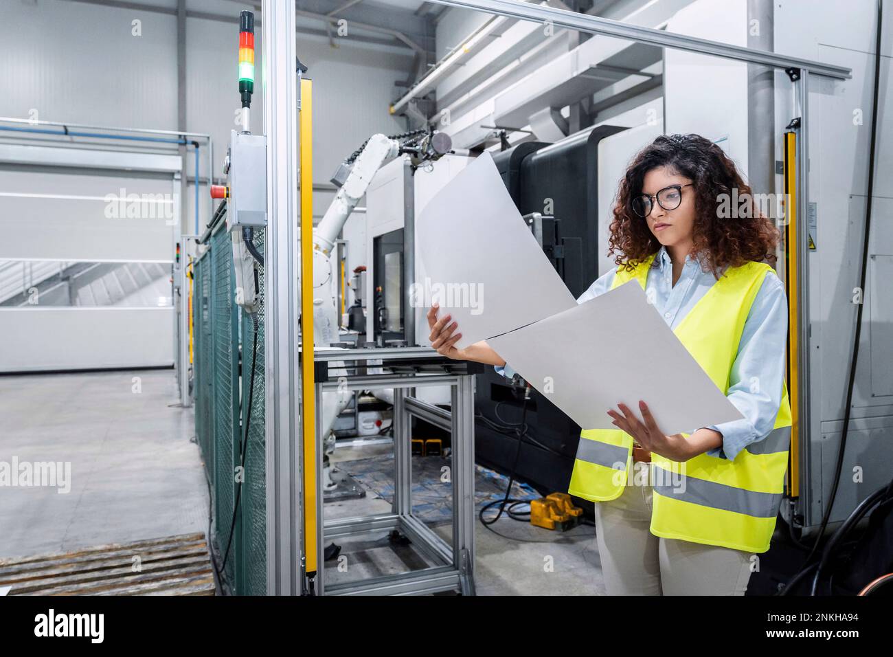 Engineer examining blueprints standing by machine in industry Stock ...